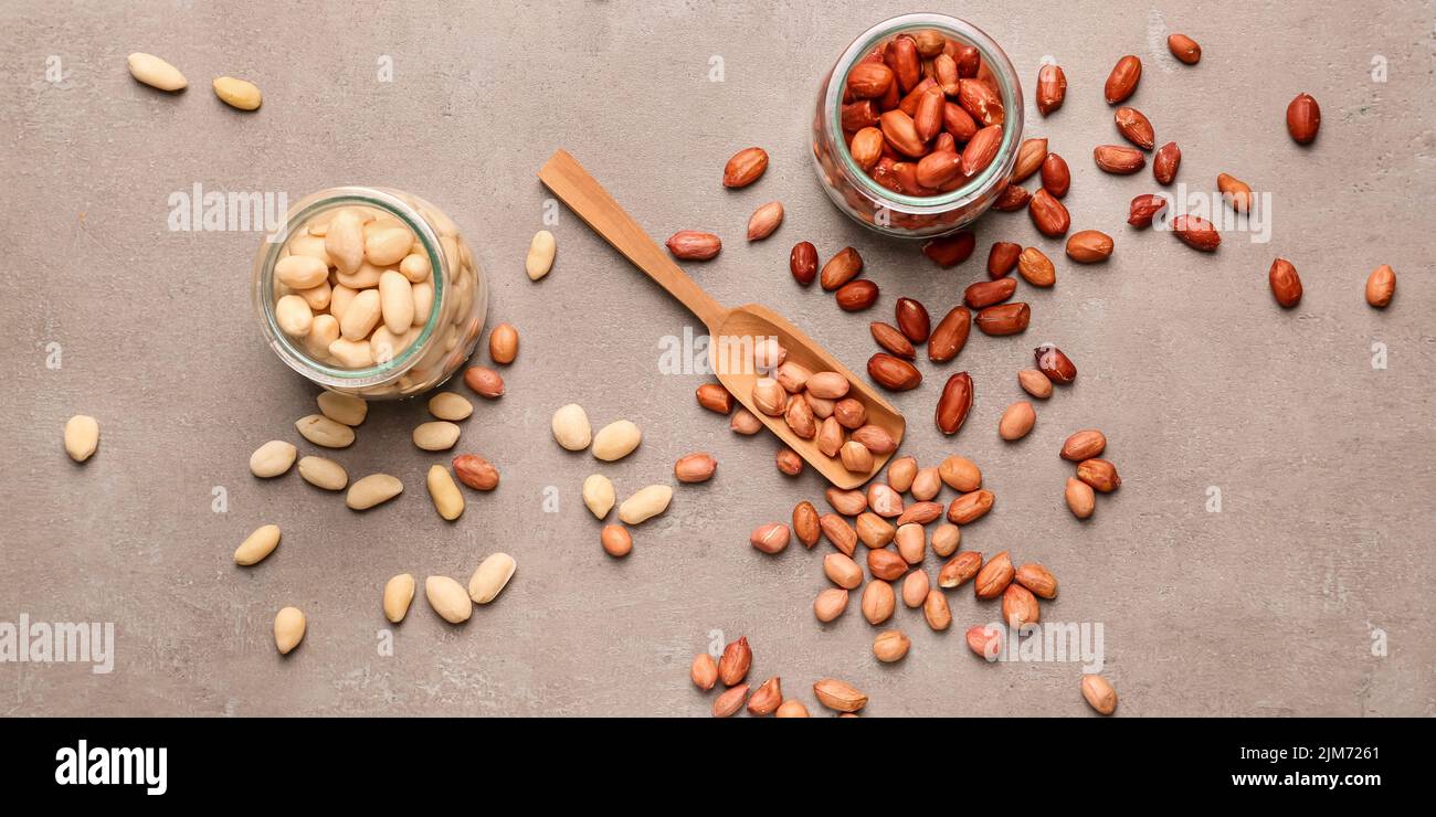Jars with tasty peanuts on color background Stock Photo - Alamy
