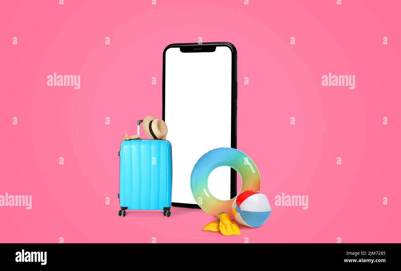 Big mobile phone with empty screen, packed suitcase and accessories on ...