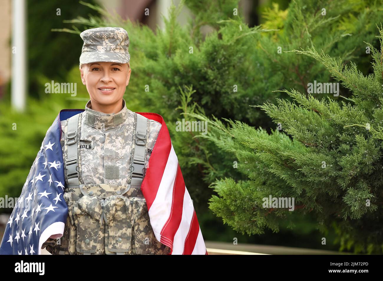 Mature female soldier with USA flag outdoors Stock Photo - Alamy