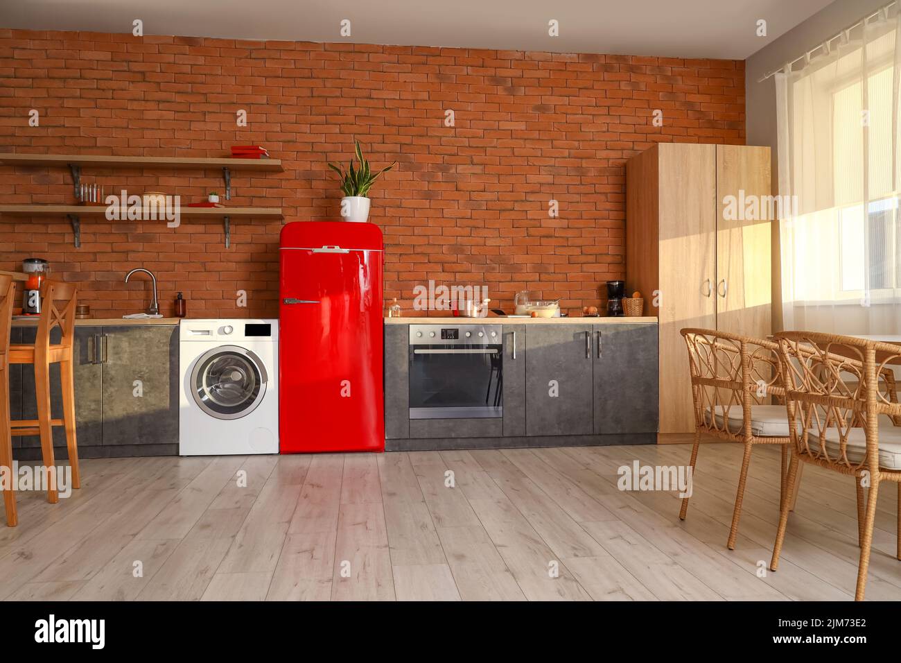 Interior of stylish kitchen with washing machine, fridge and counters ...