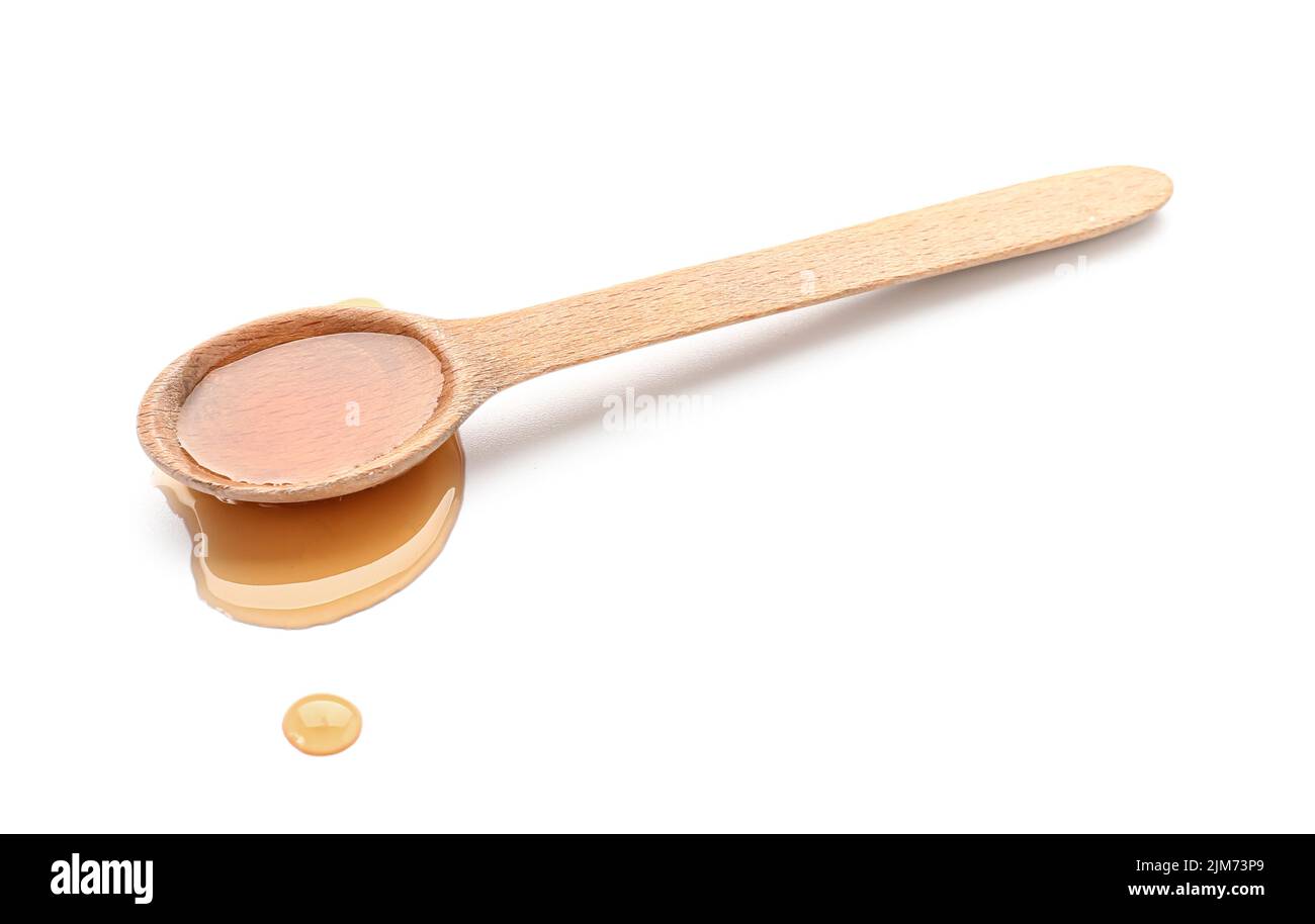 Wooden spoon of maple syrup on white background Stock Photo - Alamy