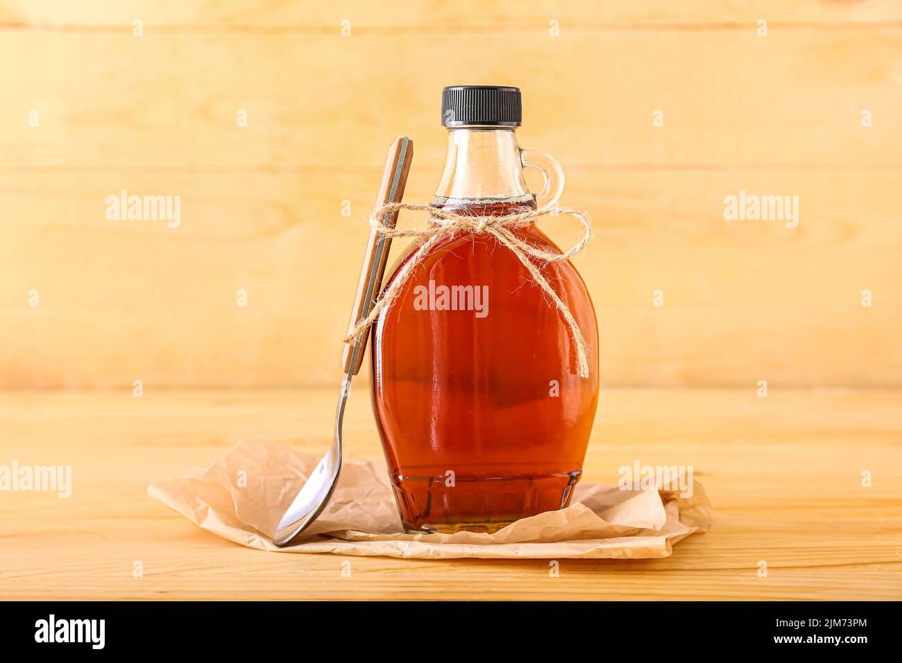 Bottle of maple syrup and spoon on wooden background Stock Photo - Alamy