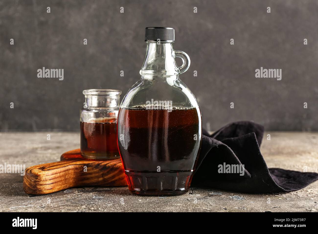 Bottles of maple syrup on grunge background Stock Photo - Alamy