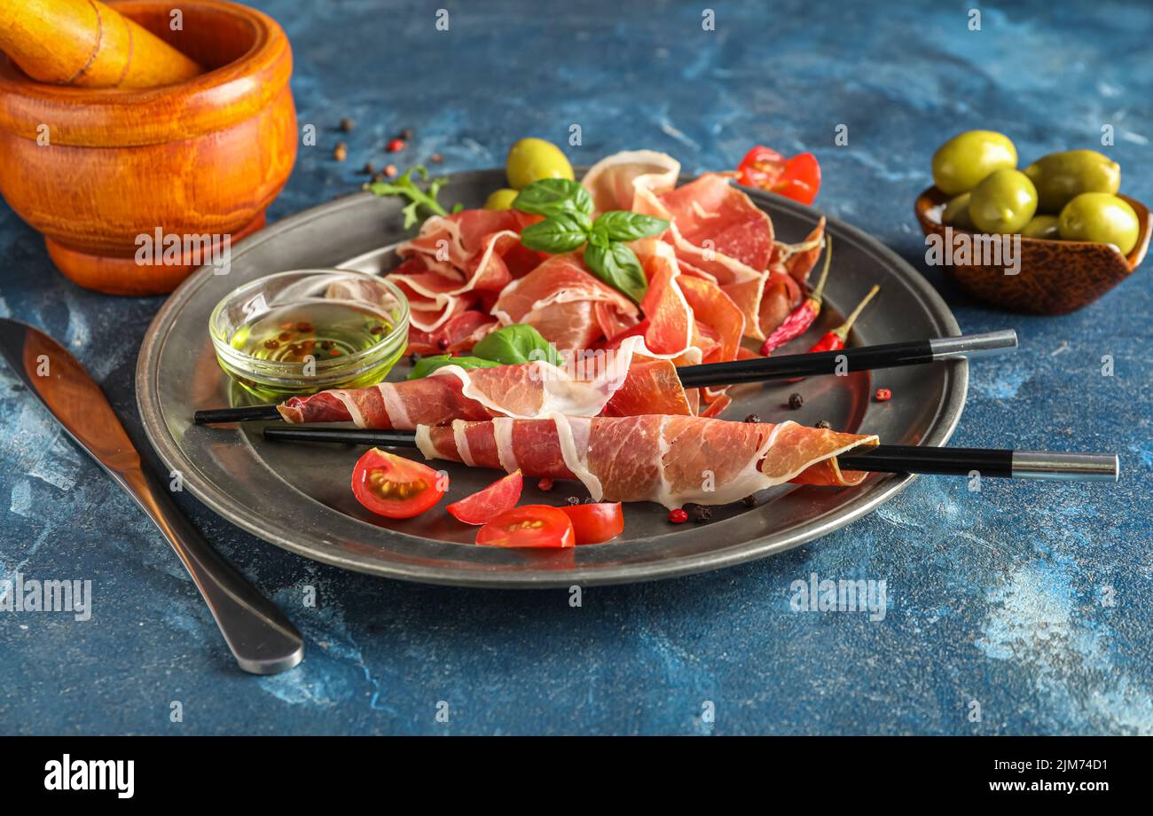 Plate with delicious jamon and bowl of oil on color background Stock ...