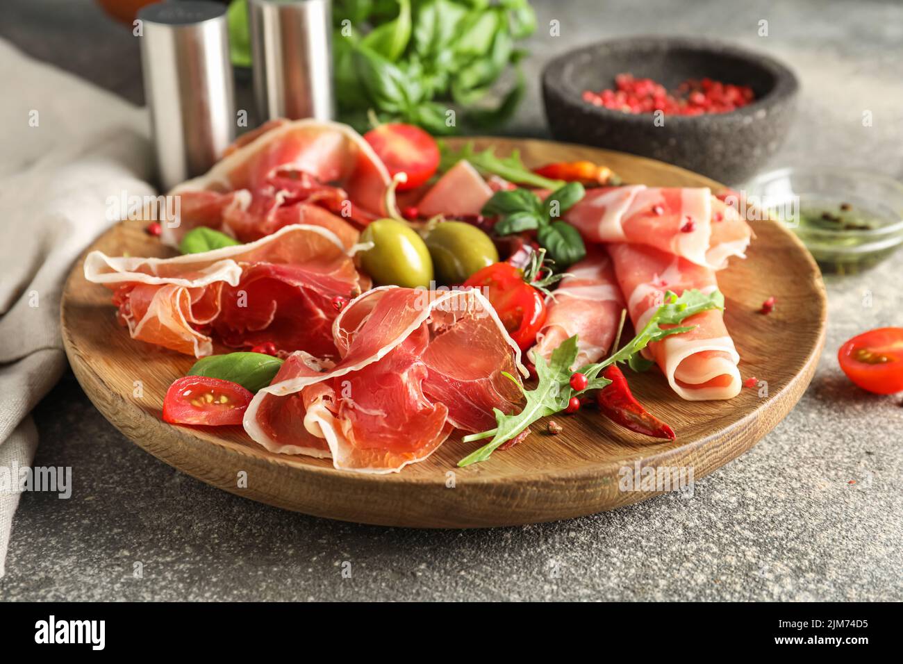Wooden plate with delicious jamon on grunge background, closeup Stock ...