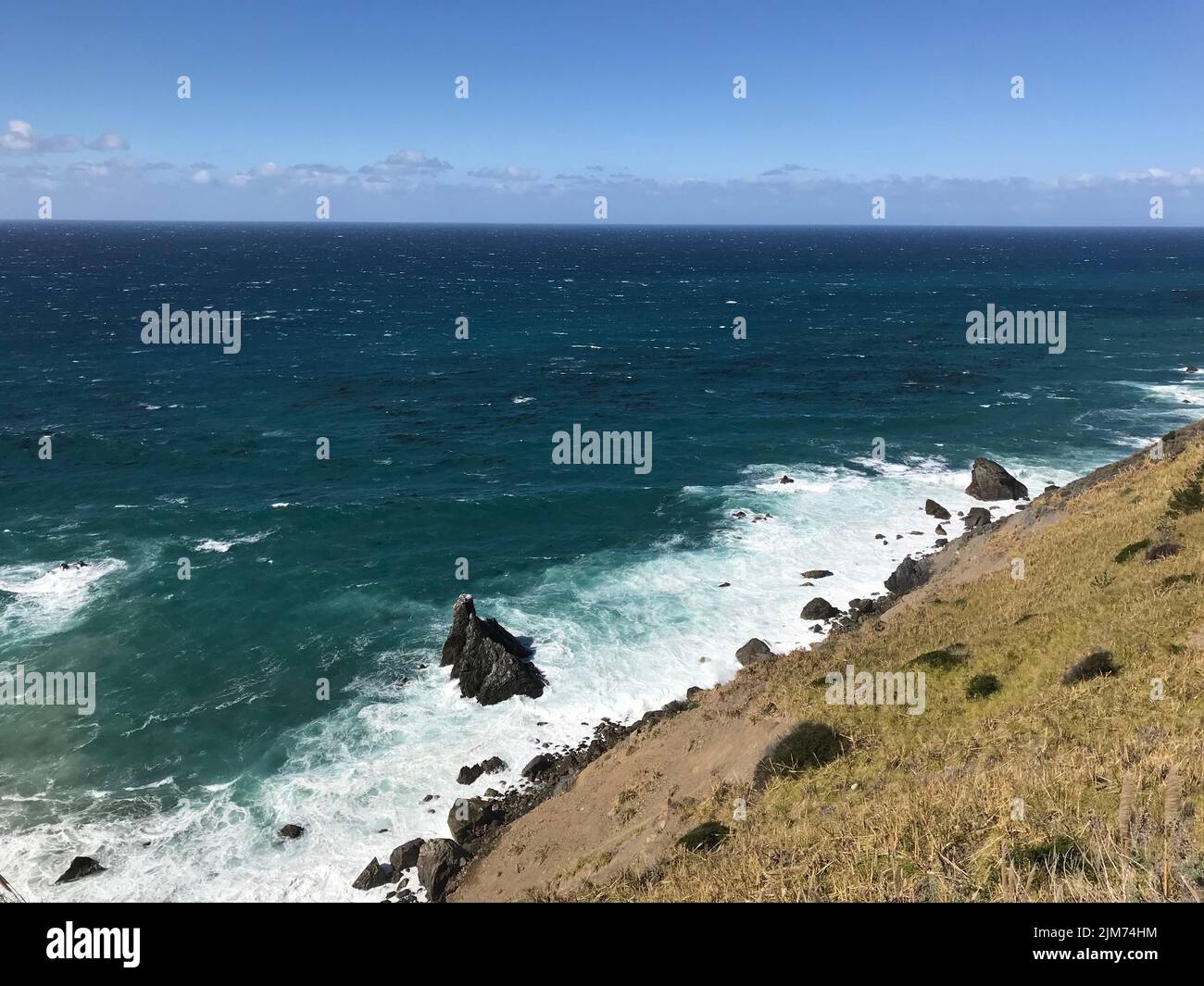 A high angle shot of coastal landscape and sea waves on a sunny day ...