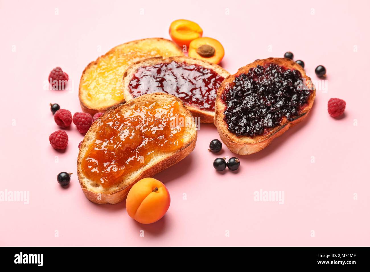 Toasts with different jams on pink background Stock Photo - Alamy