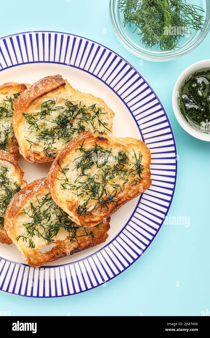 Plate with slices of toasted garlic bread on color background, closeup ...