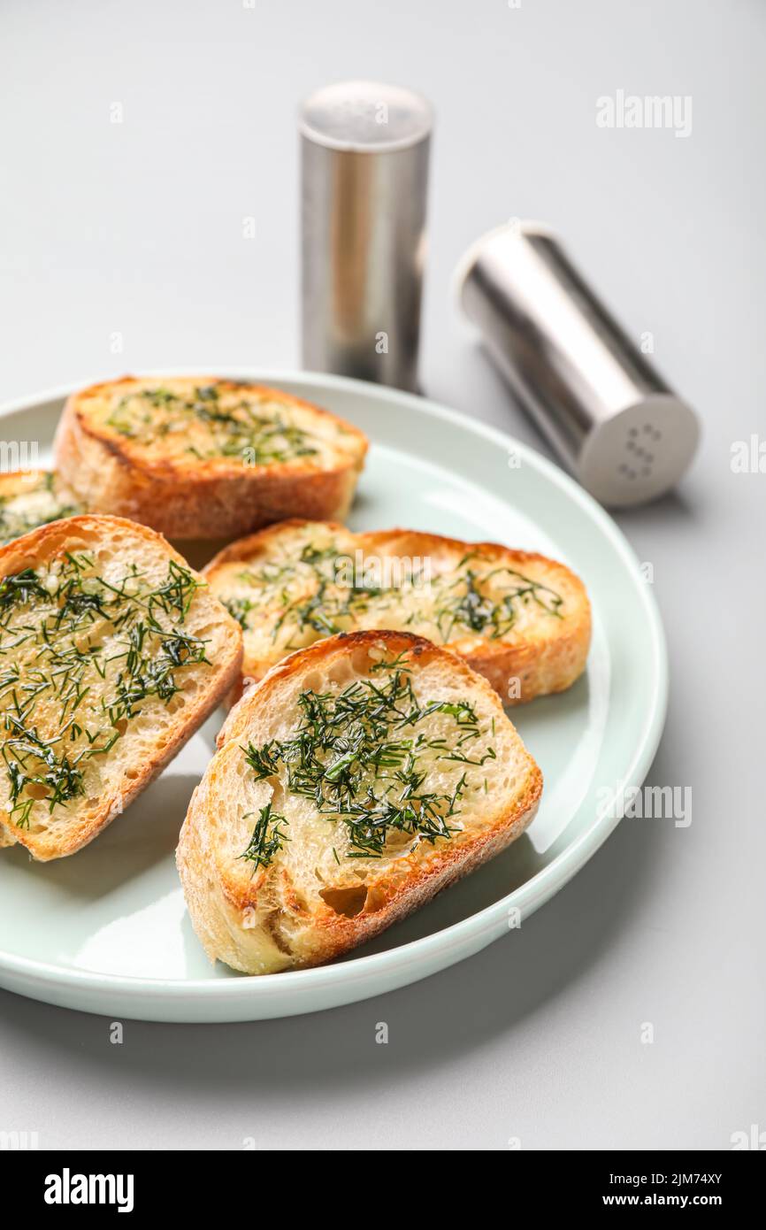 Plate with slices of toasted garlic bread on light background, closeup ...