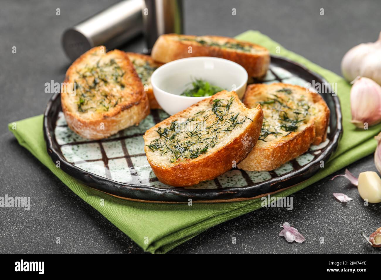 Plate with slices of toasted garlic bread on dark background, closeup ...