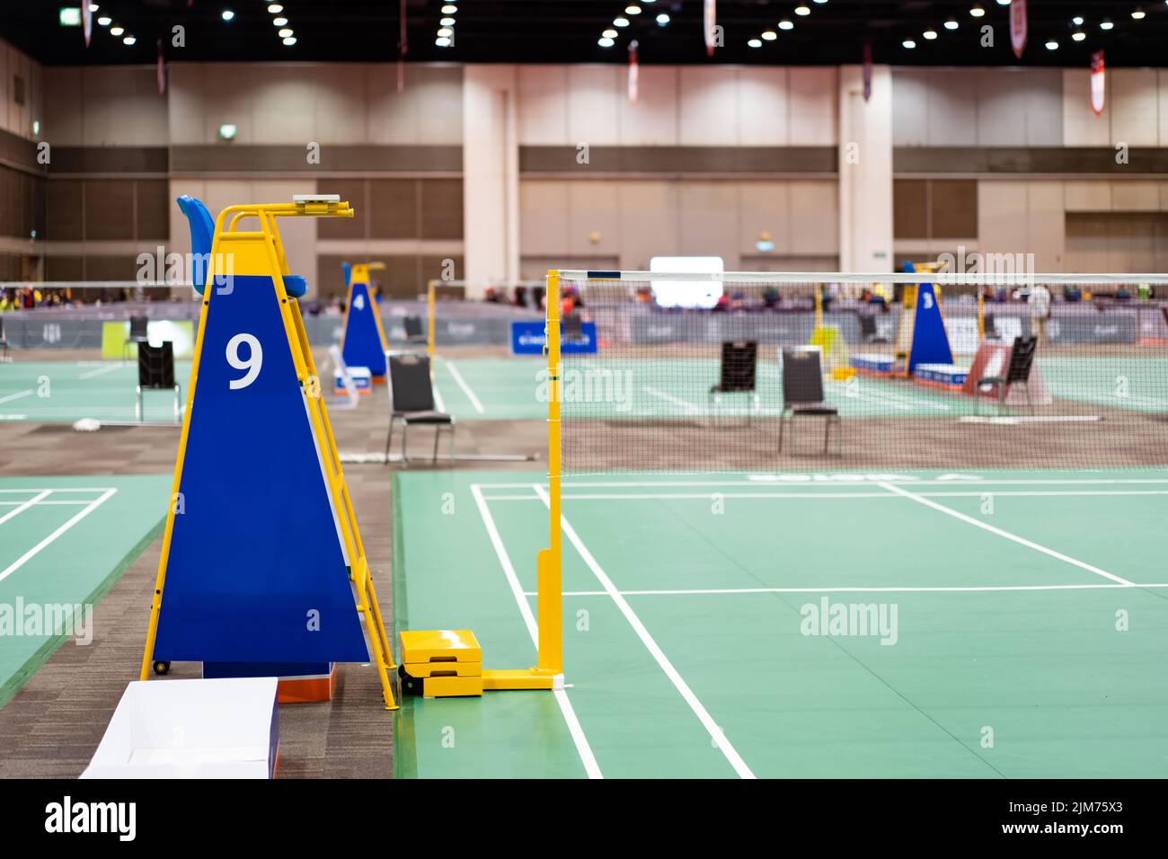 Blue chair of badminton referee with yellow colors near badminton net ...