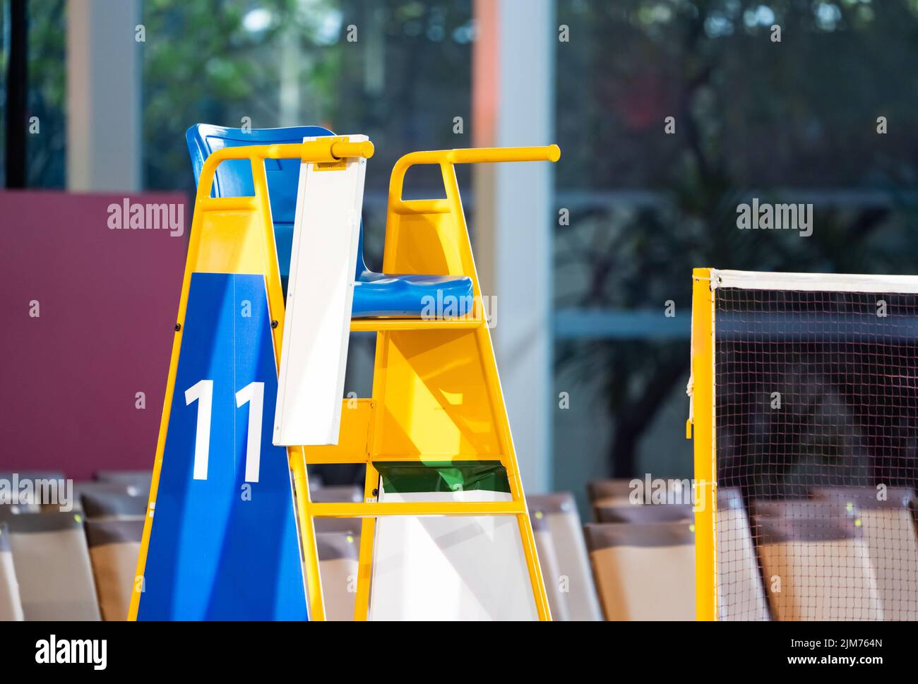 Blue chair of badminton referee with yellow colors near badminton net ...