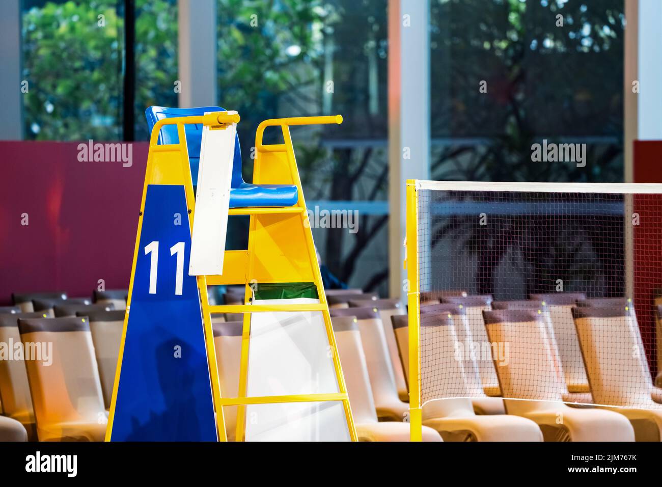 Blue chair of badminton referee with yellow colors near badminton net ...