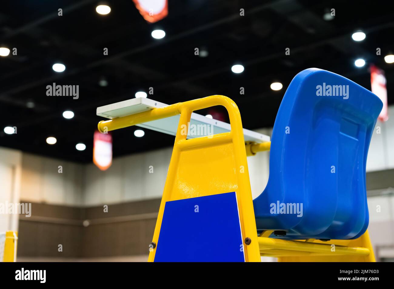 Blue chair of badminton referee with yellow colors near badminton net ...