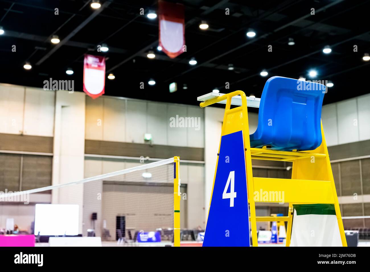 Blue chair of badminton referee with yellow colors near badminton net ...