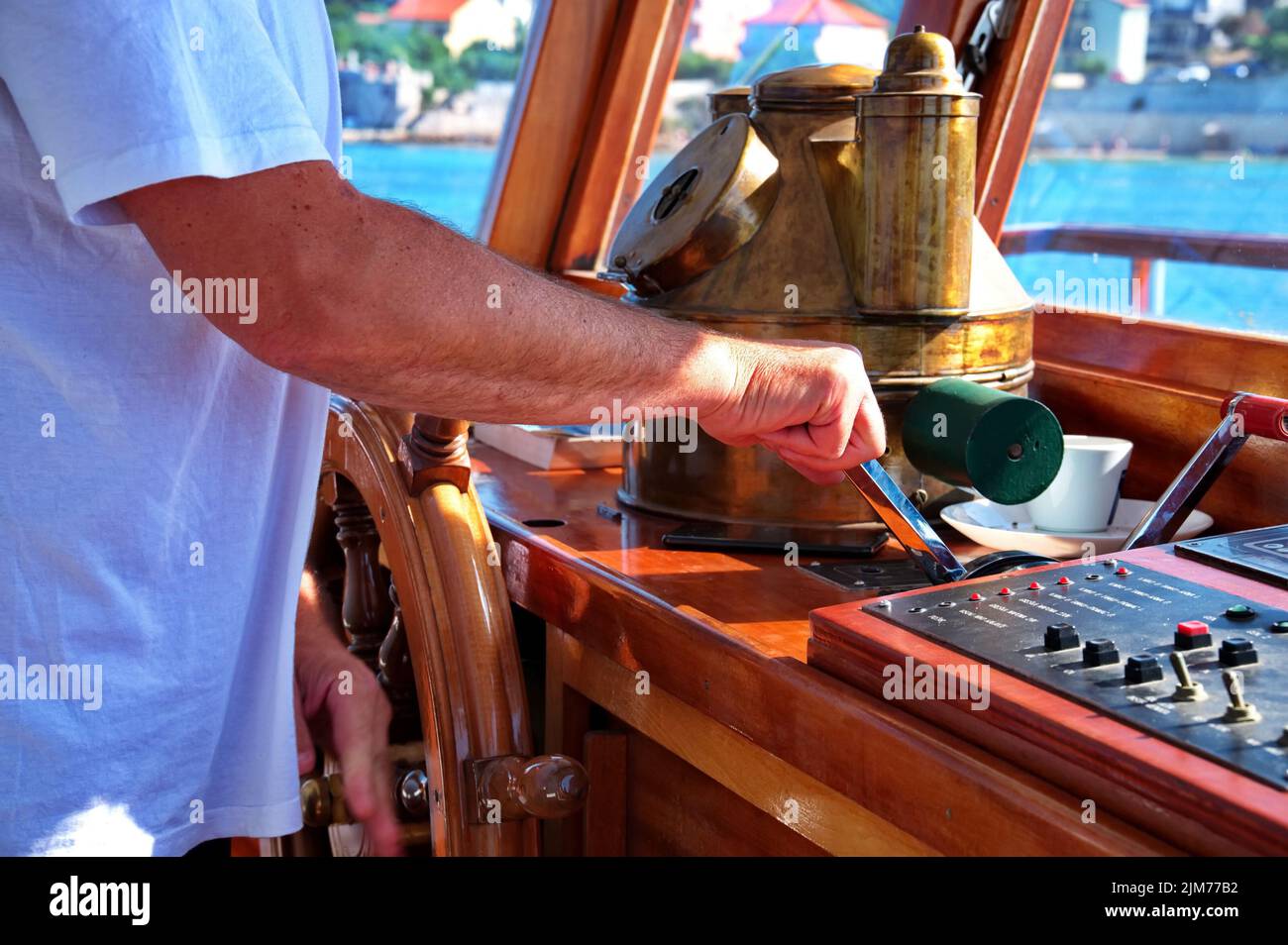 Midsection of captain holding hands on ship rudder Stock Photo - Alamy