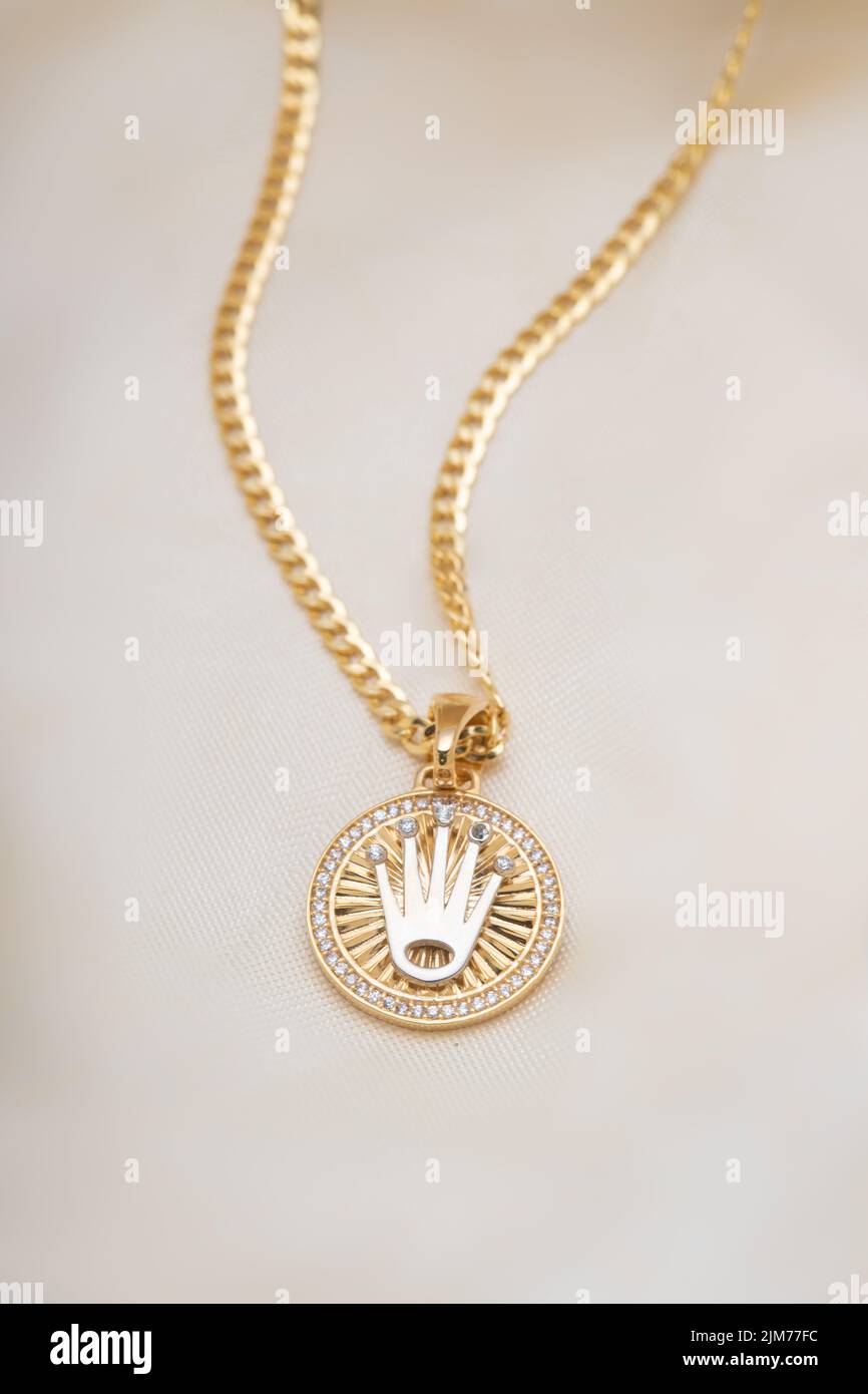 A closeup shot of a piece of golden necklace with one hand design on a ...