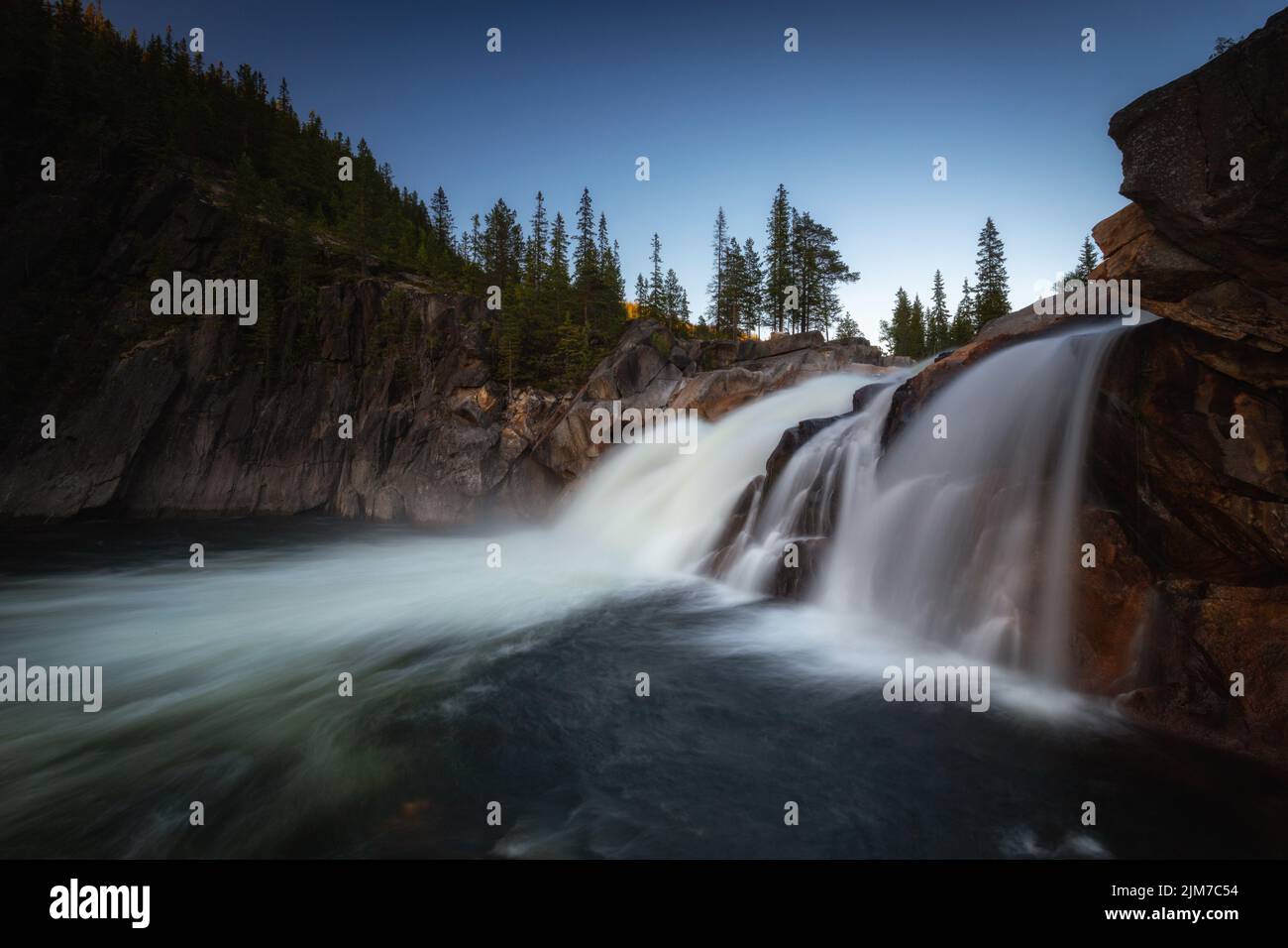 Hyttfossen waterfall during sunset time. Long exposure time on flowing ...