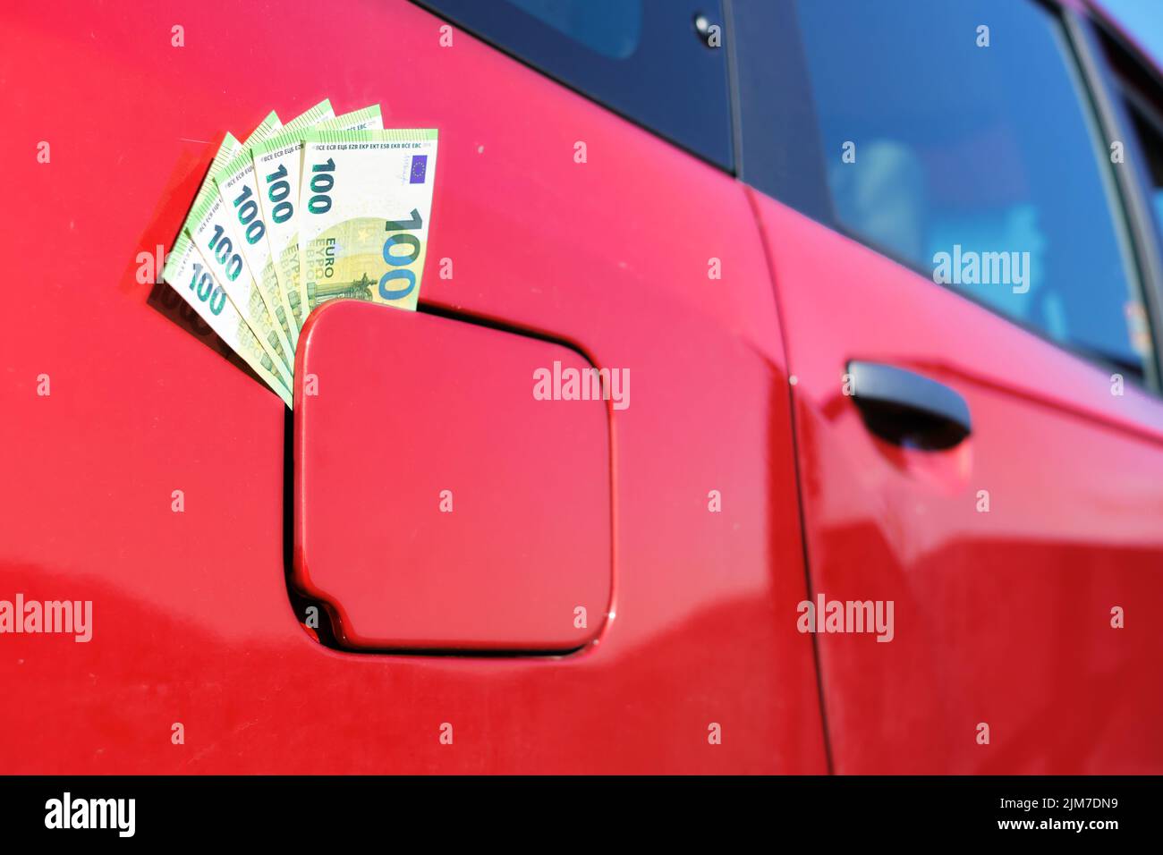A bundle of one hundred euro banknotes in the fuel tank cap of a car ...