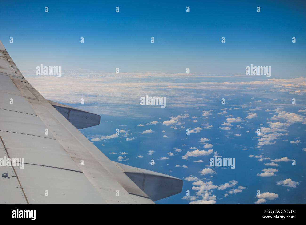 View over wing of commercial airplane flying at high altitude over ...