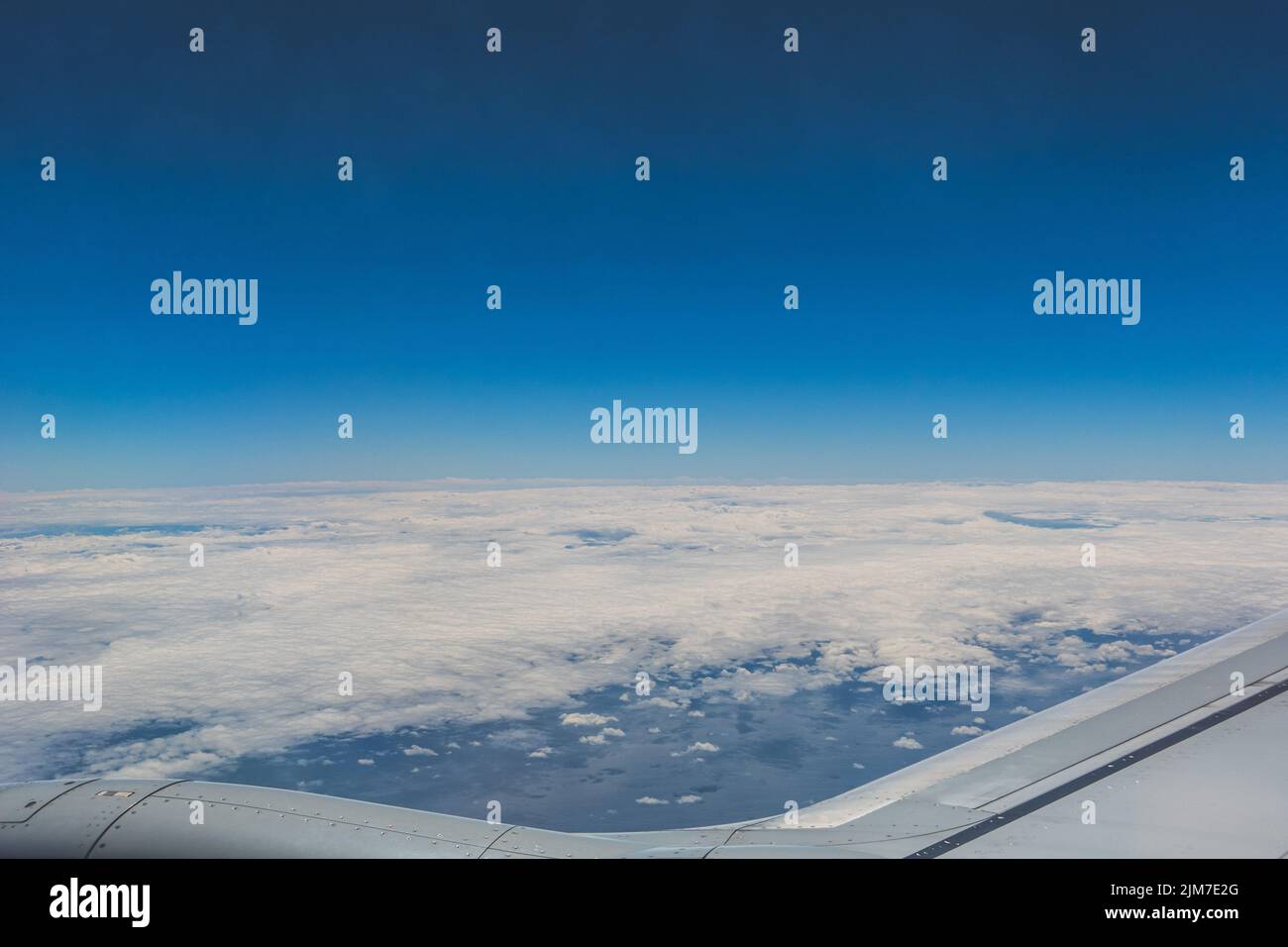 View over wing of commercial airplane flying at high altitude over ...