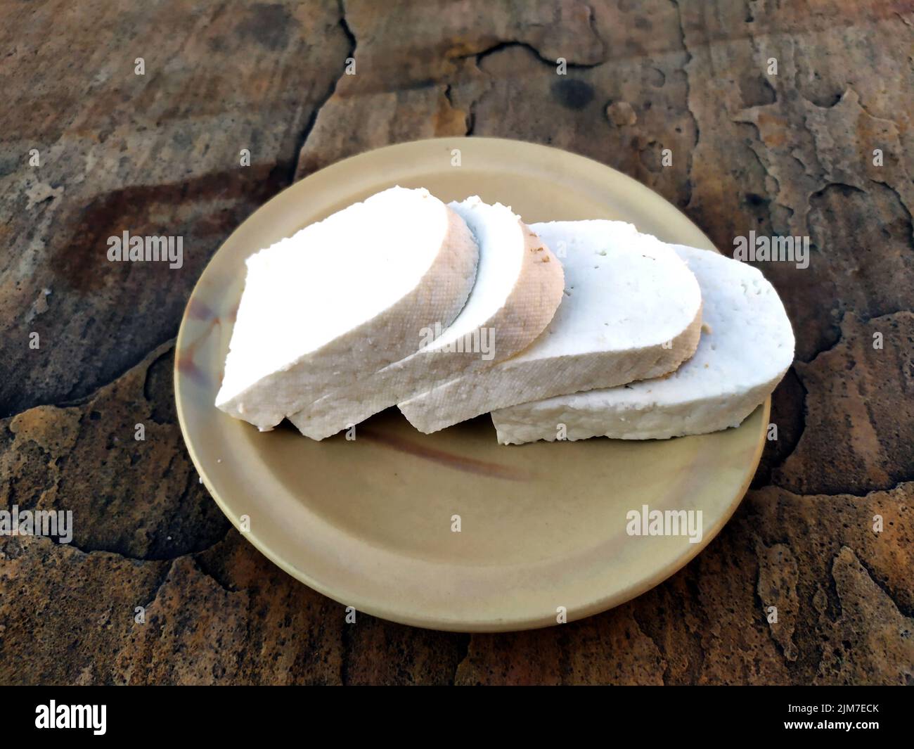 paneer slice put in a plate with stone background Stock Photo - Alamy