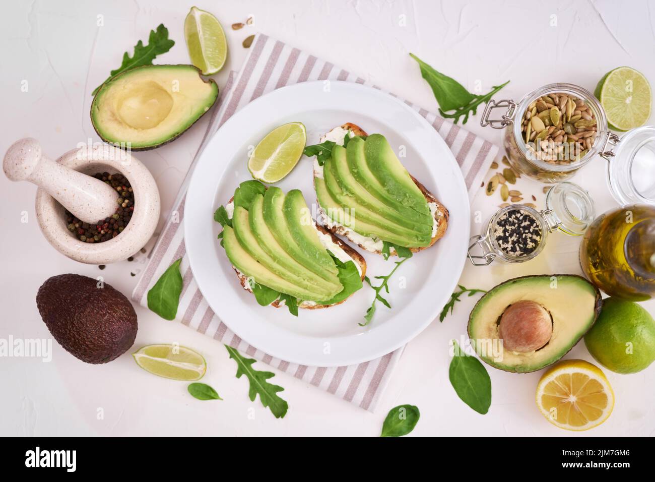 Freshly made Avocado and cream cheese toasts on a white ceramic plate ...