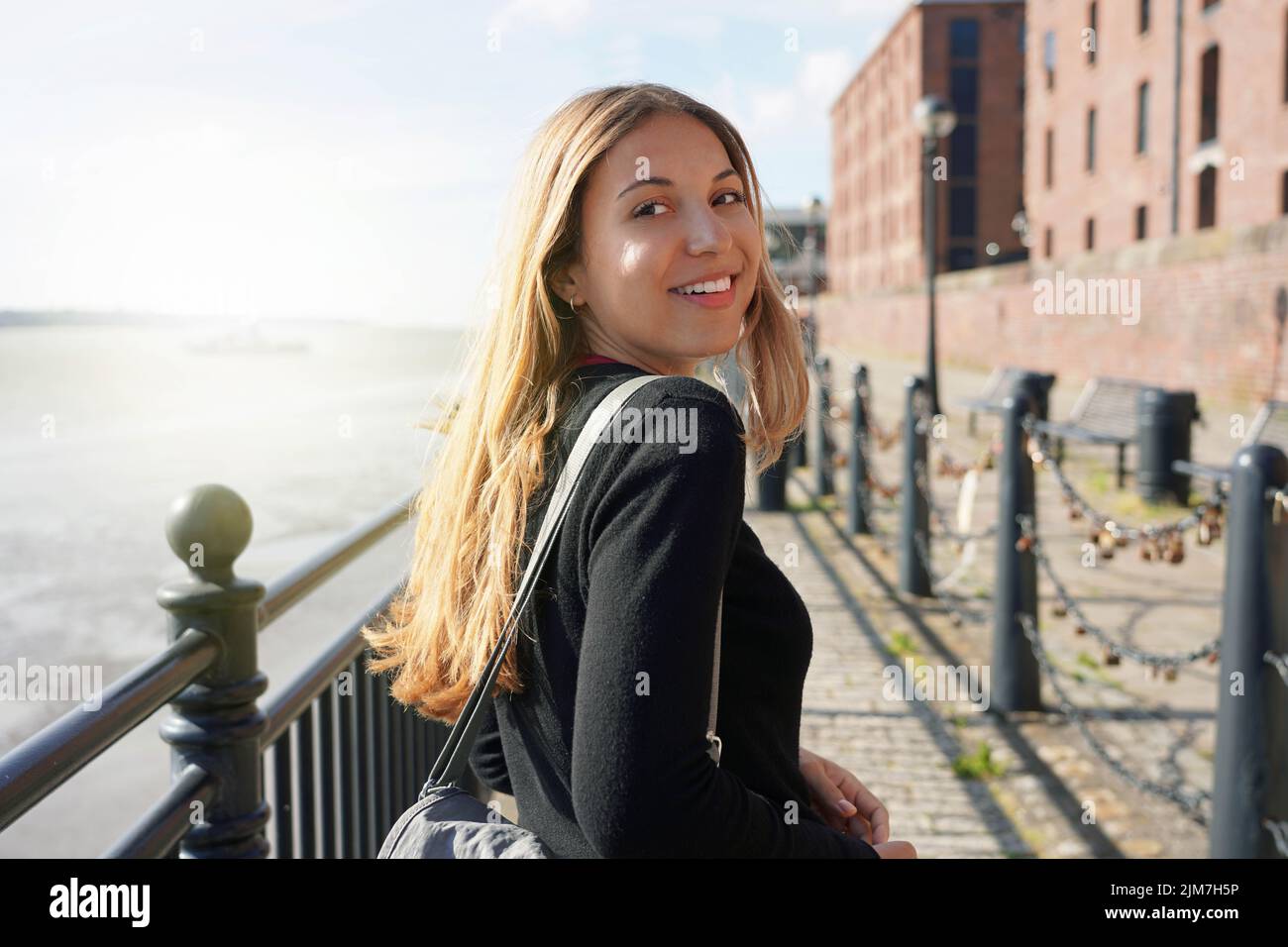 Portrait of beautiful woman turns and smiling to the camera walking on ...