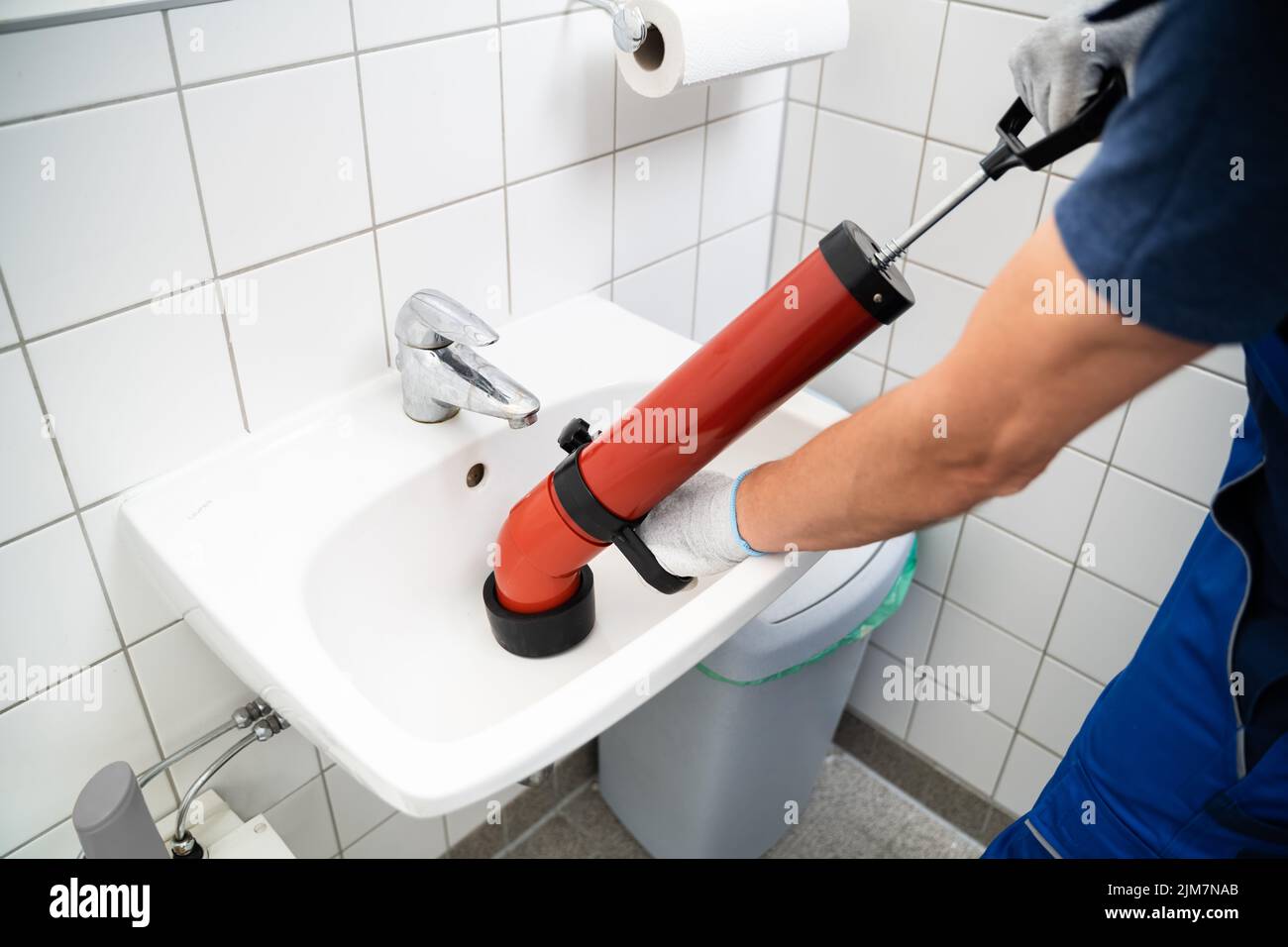 Plumber Cleaning Drain And Bathroom Sink Using Pump Stock Photo - Alamy