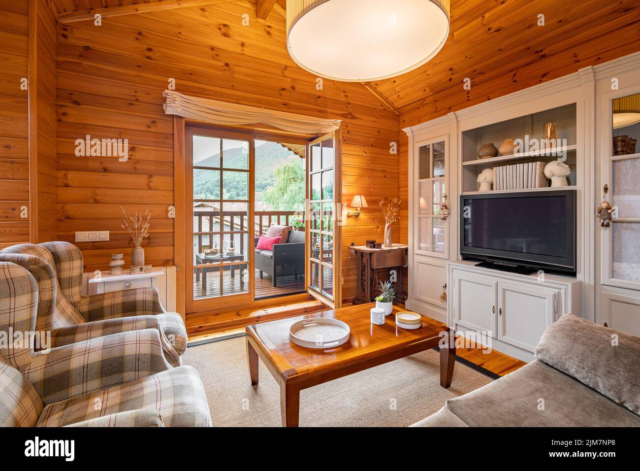 Beautiful interior of cozy living room with view of terrace in a wooden ...