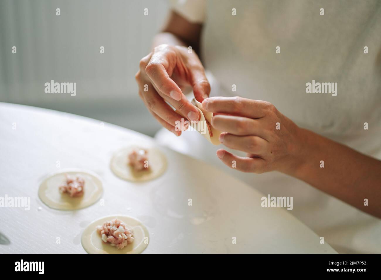 Woman making dumplings. Front view of woman's hands making meat ...
