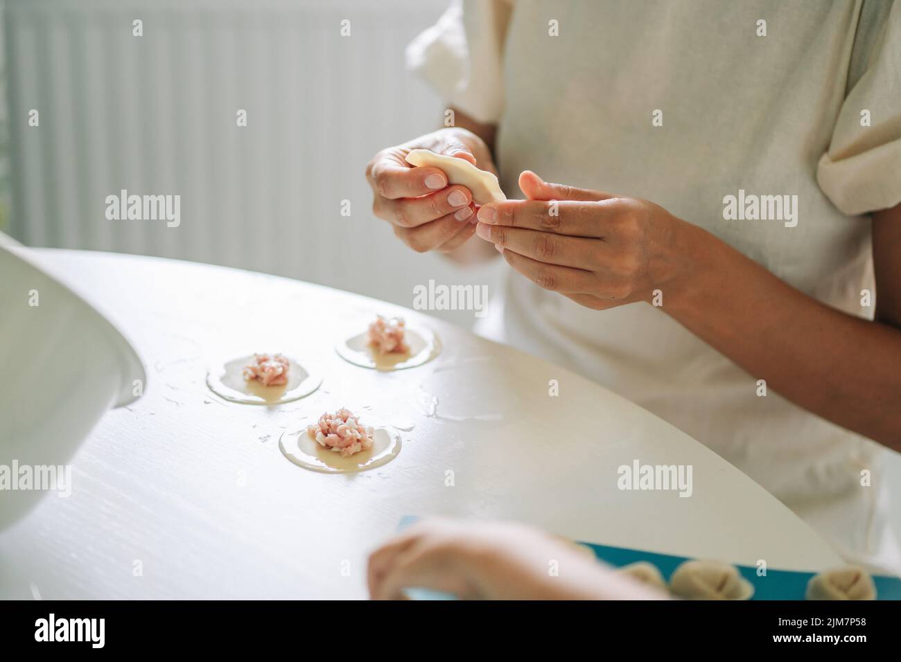 Woman making dumplings. Front view of woman's hands making meat ...
