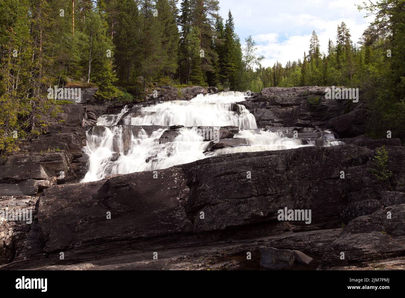 Waterfall in the woodland, mountain. Rocks and cliffs, forest, and ...