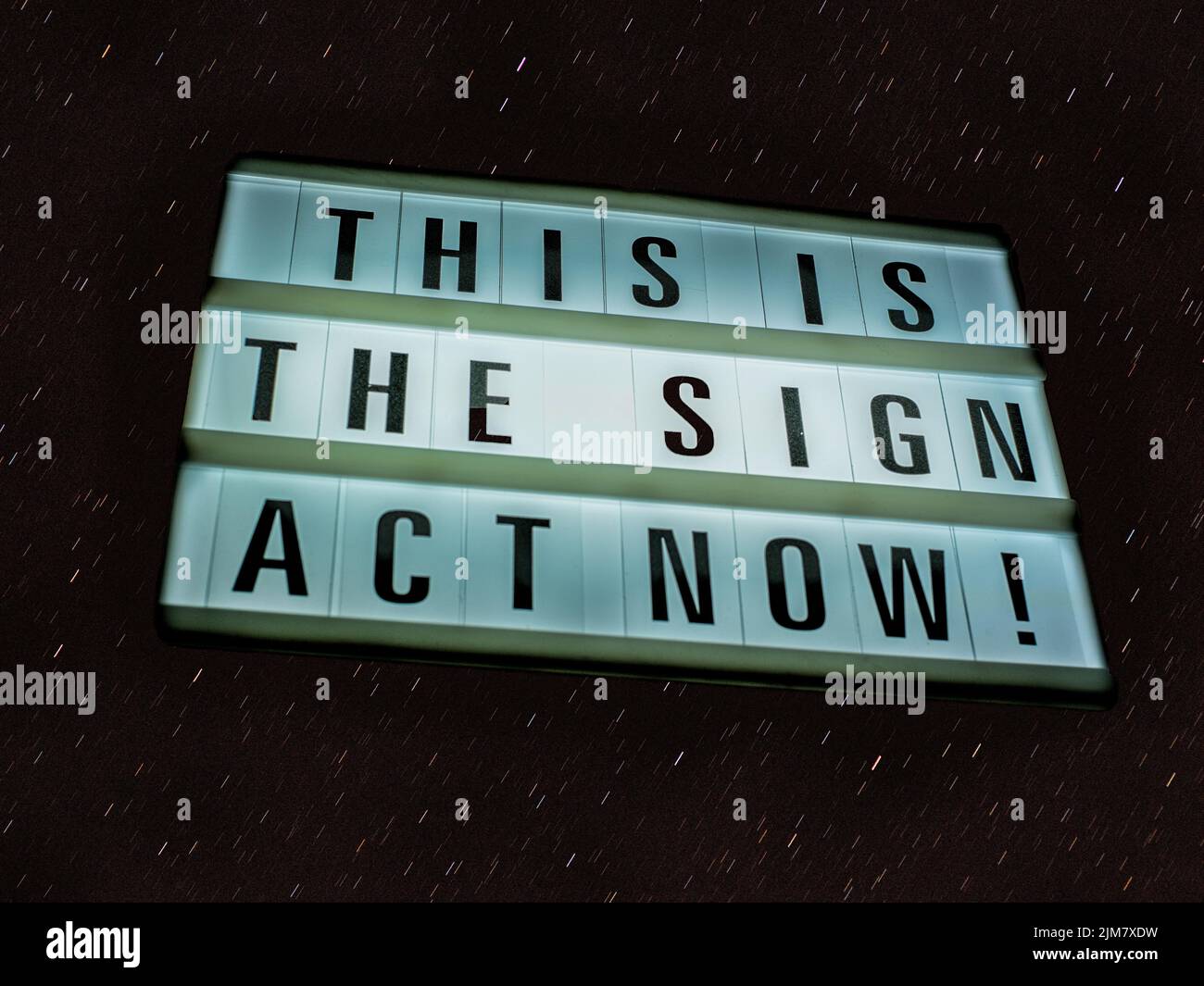 illuminated sign with individual letters giving the message to act now ...