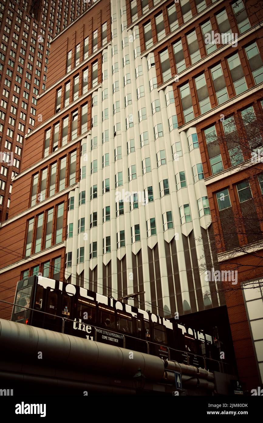 A vertical shot of a brown, tall building with a white part in the ...