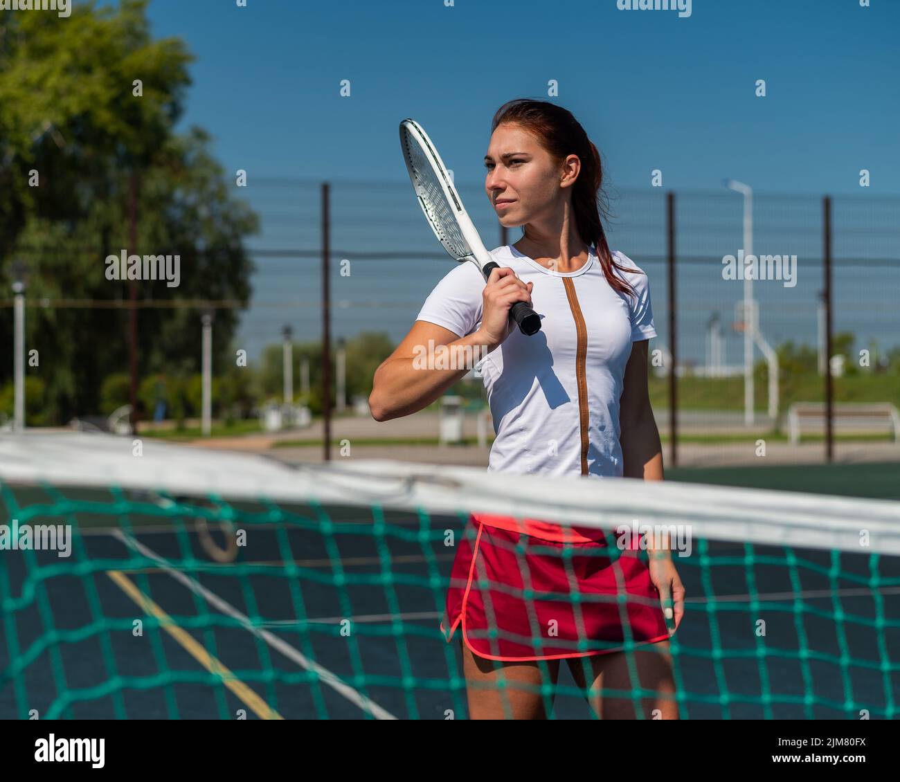 Beautiful smiling woman with a shadow from a tennis racket on her face ...