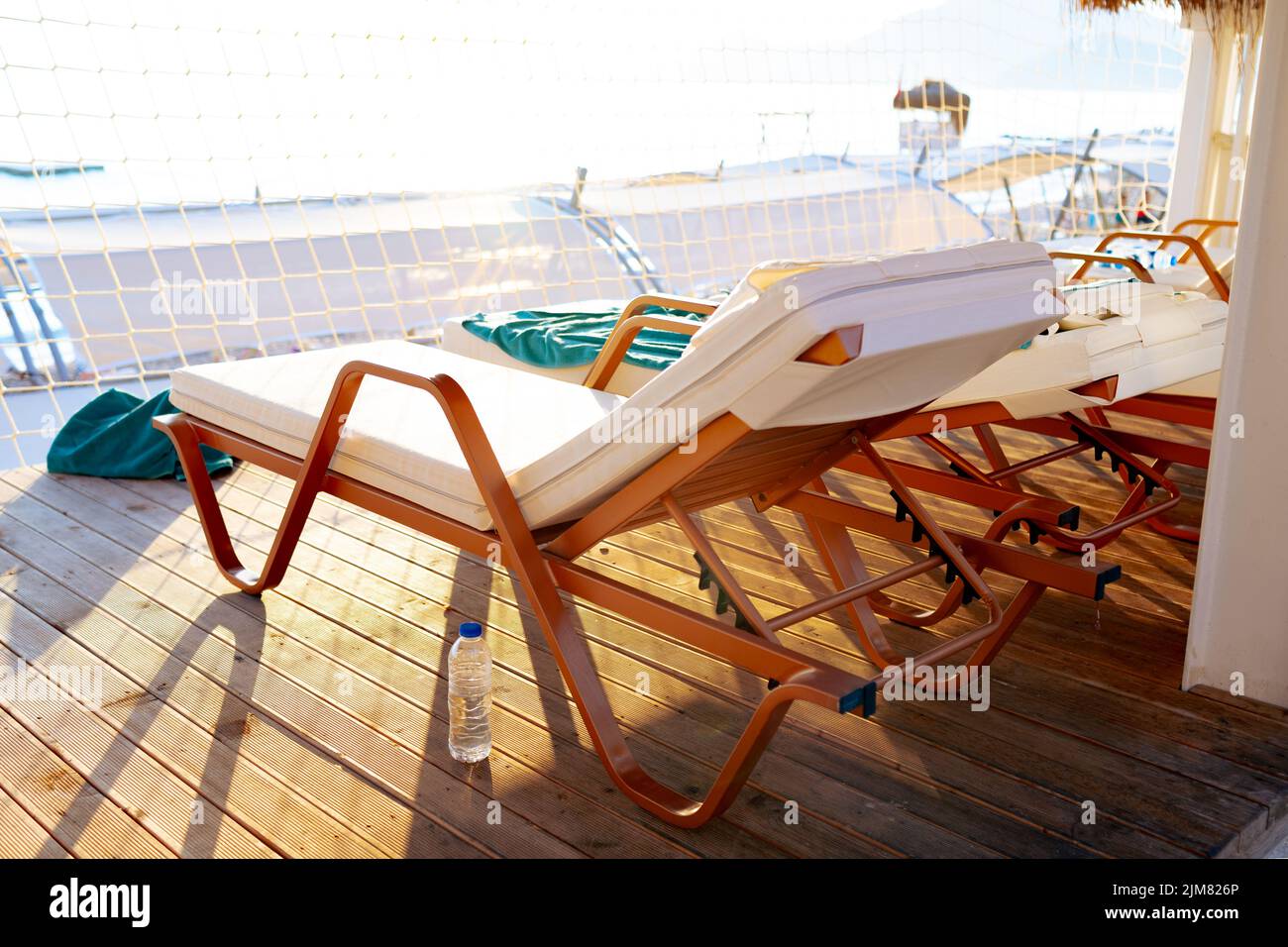 Empty deck chairs with white mattresses in resort hotel Stock Photo - Alamy