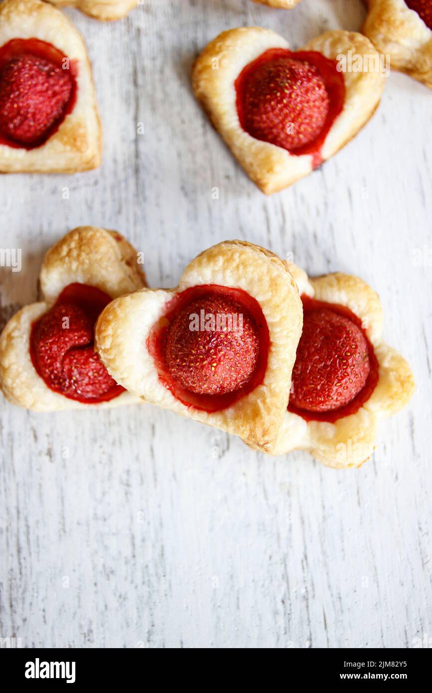 Puff pastry cookies in heart shape filled with strawberries. Party ...