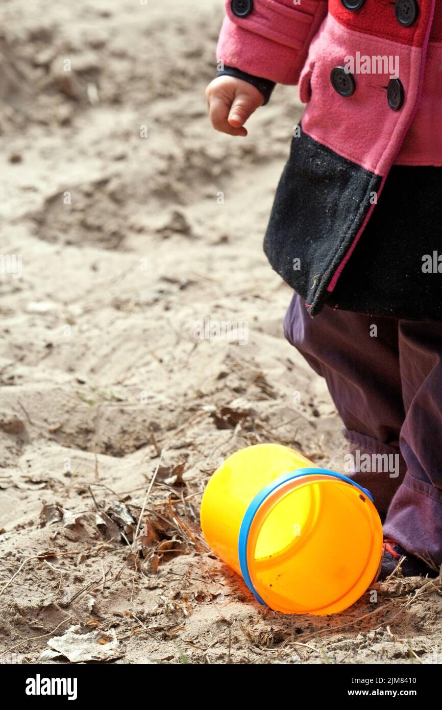 Kid's hand and toy bucket Stock Photo - Alamy