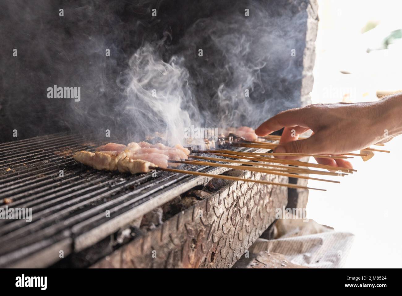 Flipping around meat on wooden sticks, algerian traditional food, over ...
