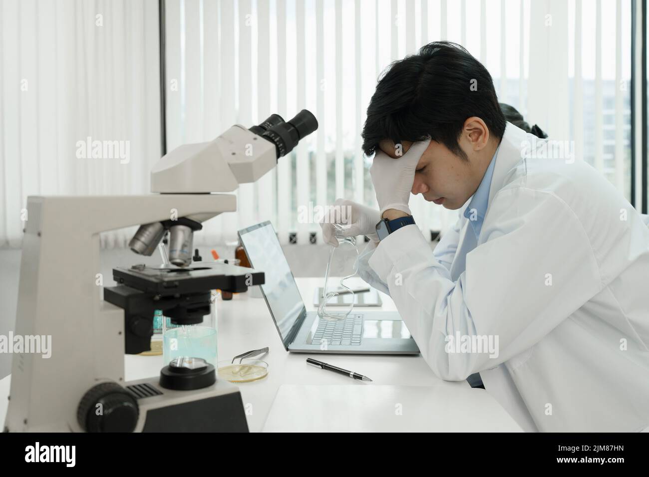 Stressed male scientist and hard working at laboratory Stock Photo - Alamy