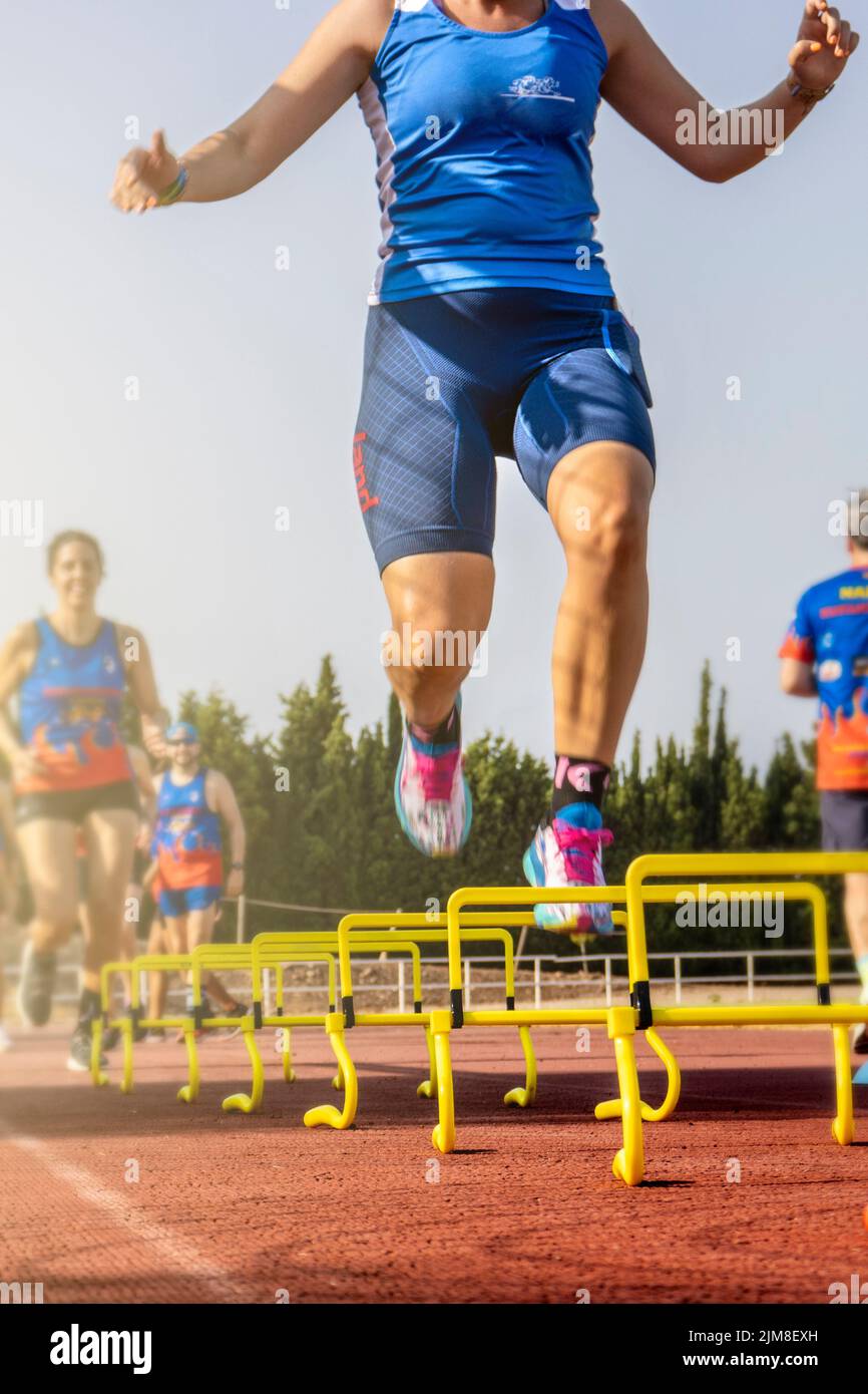 Woman runner flying while jumping over obstacles. I believe I can fly ...