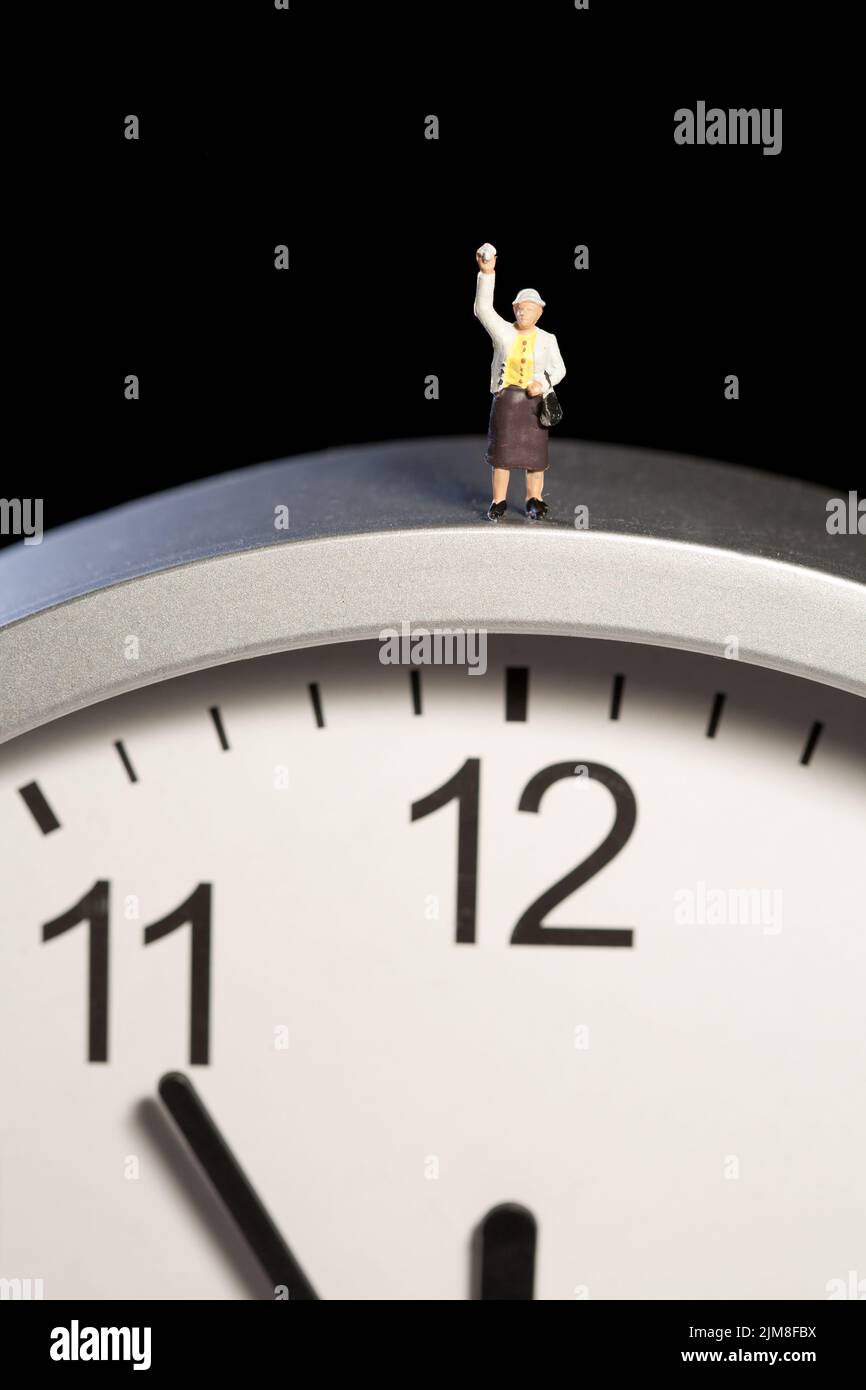 Older lady waves with pocket ink on clock Stock Photo - Alamy