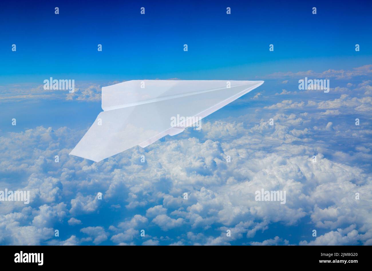 Paper plane flying in sky background Stock Photo - Alamy