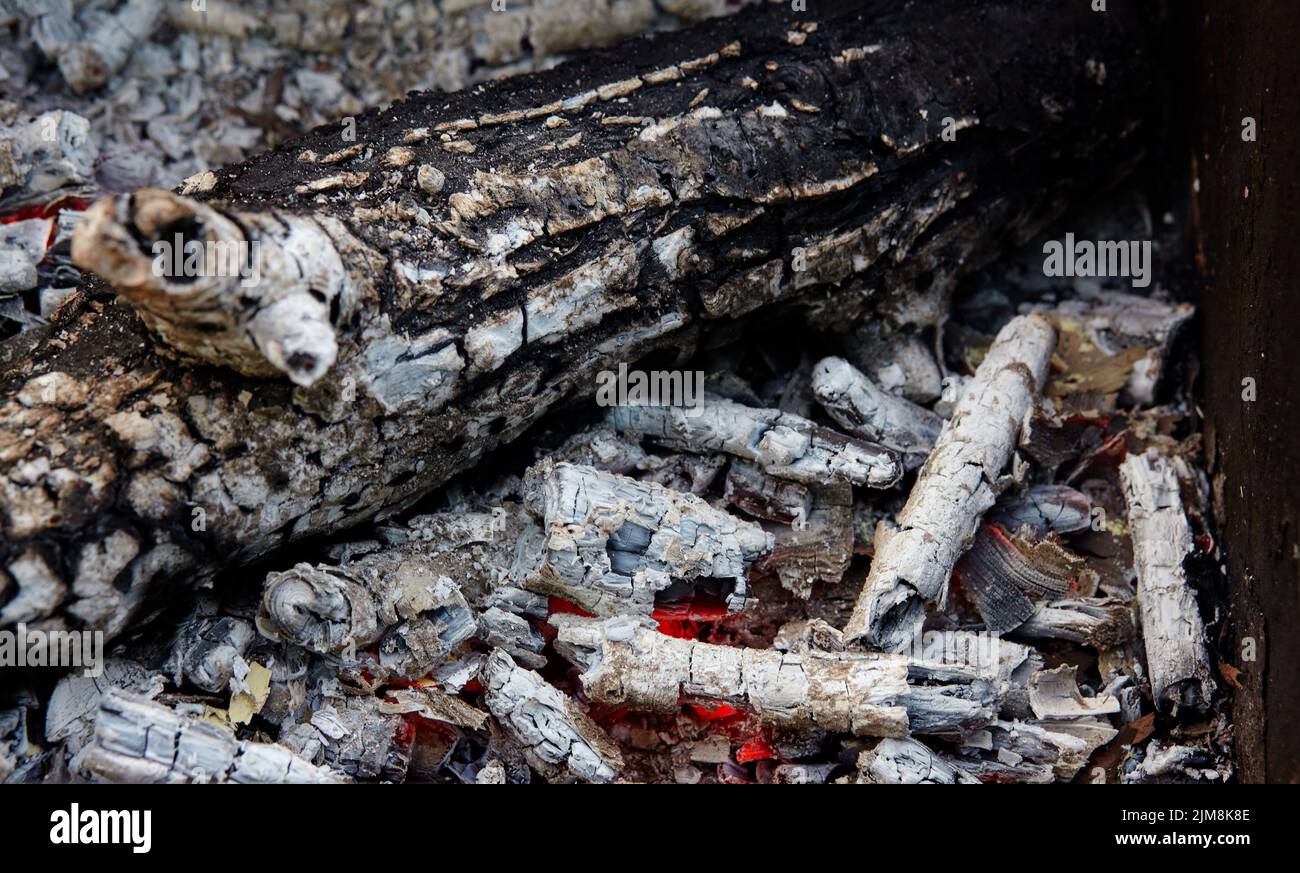Smoldering charcoal in a barbecue. Scattered pieces of embers in the ...