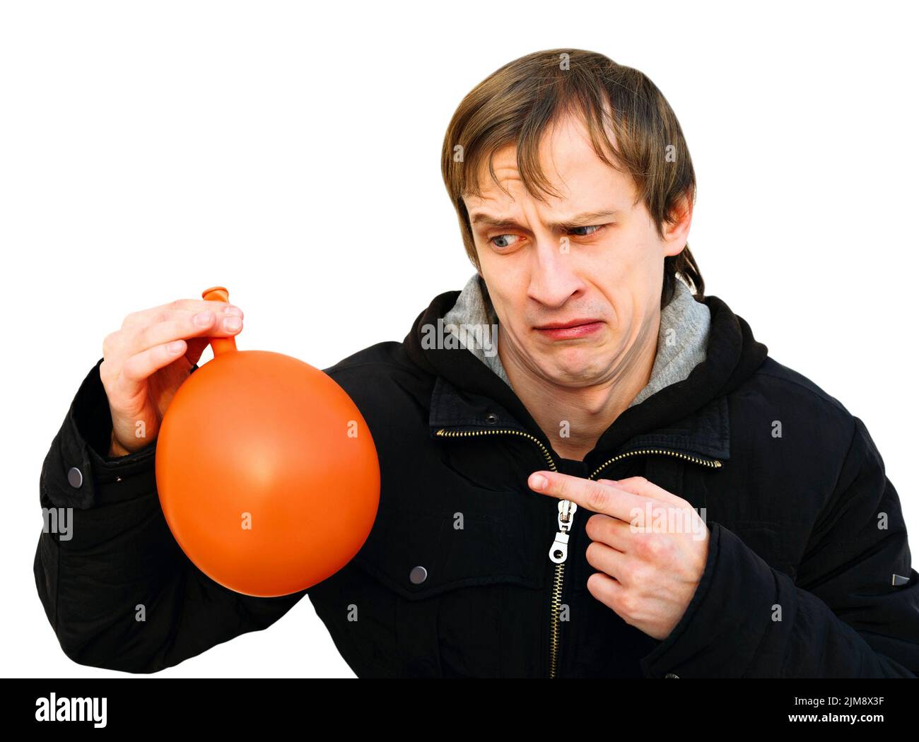 Dissatisfied young man hold a balloon which is blo Stock Photo - Alamy