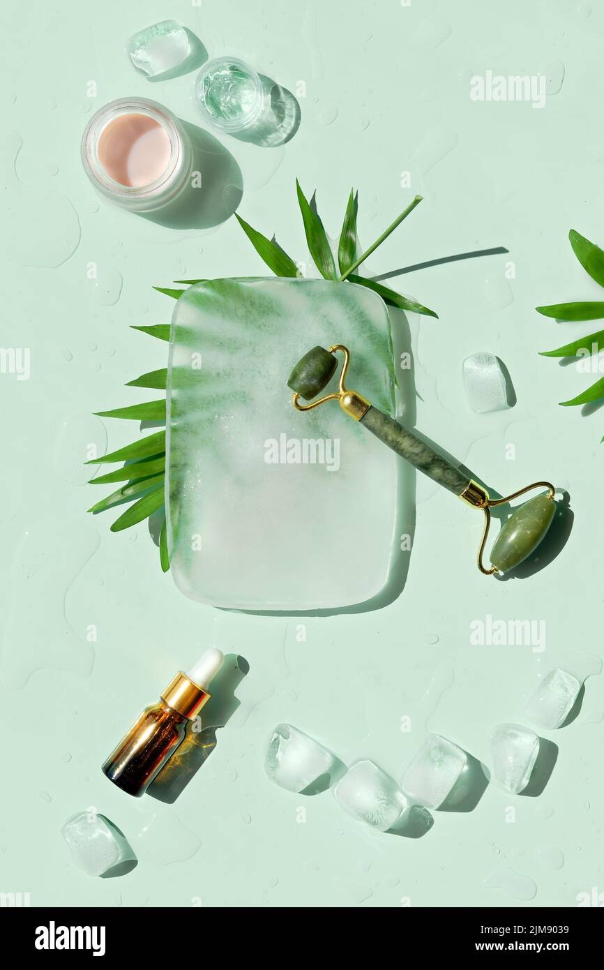 Jade stone face roller, essential oil and handmade cream with ice cubes ...