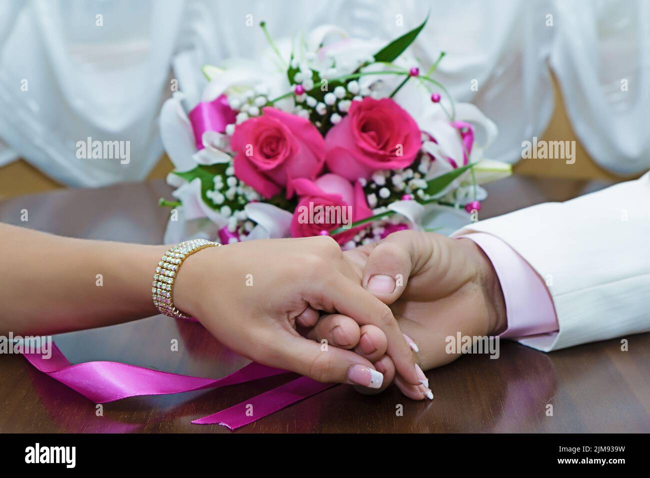 Hands of the newlyweds and bridal bouquet Stock Photo - Alamy