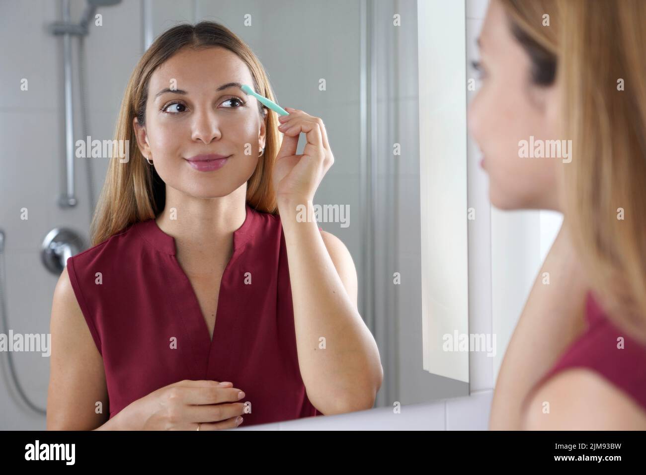 Pretty woman using razor on bathroom. Beautiful young woman shaving her ...