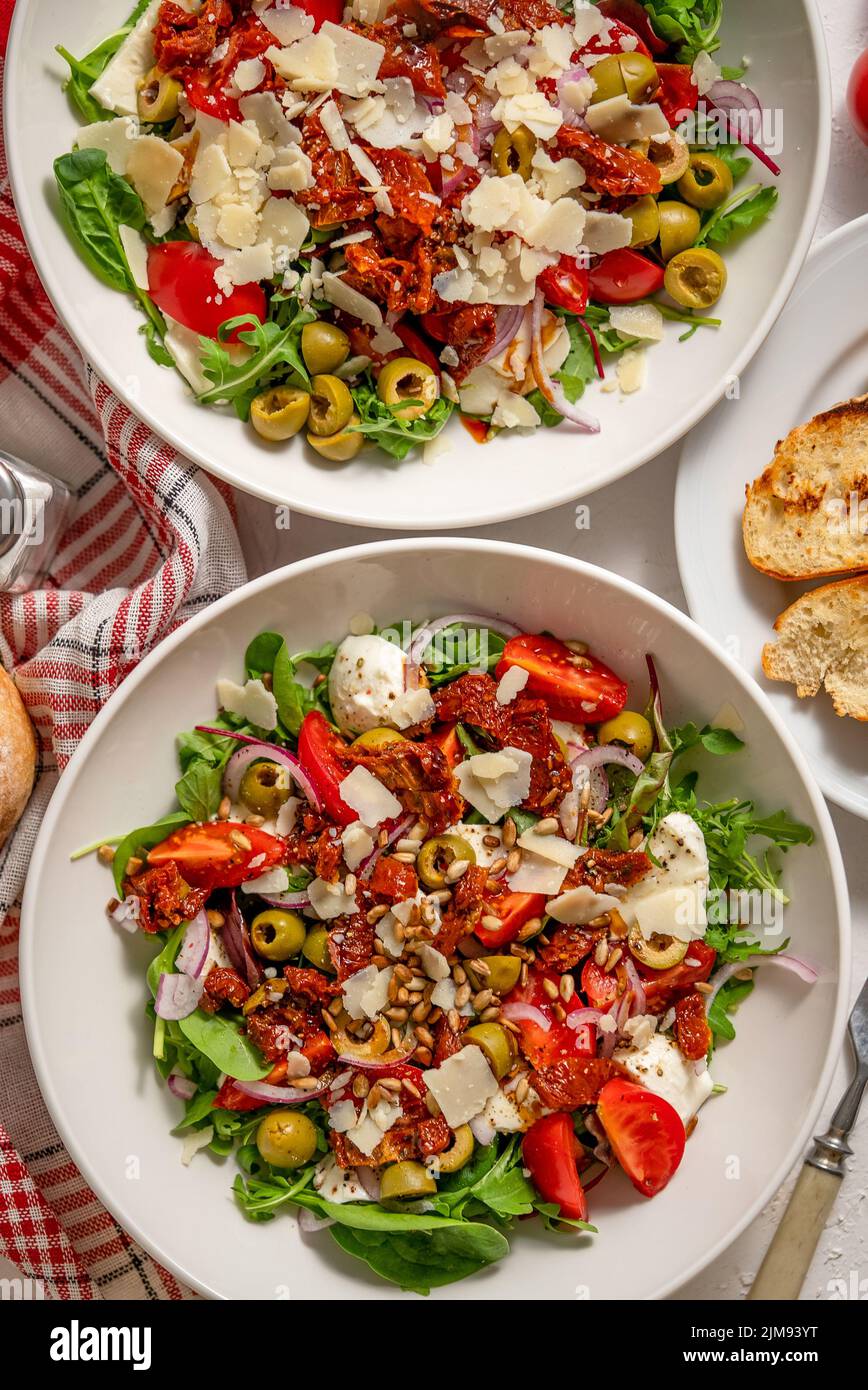 Two person meal. Tasty dried tomatoes salad with fresh vegetables mix ...